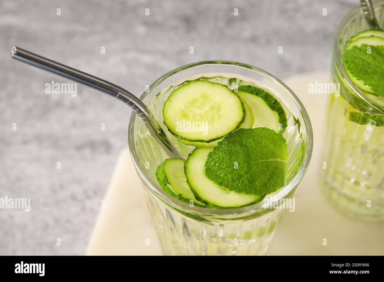 Glass with cucumber lemonade on grey background Stock Photo - Alamy