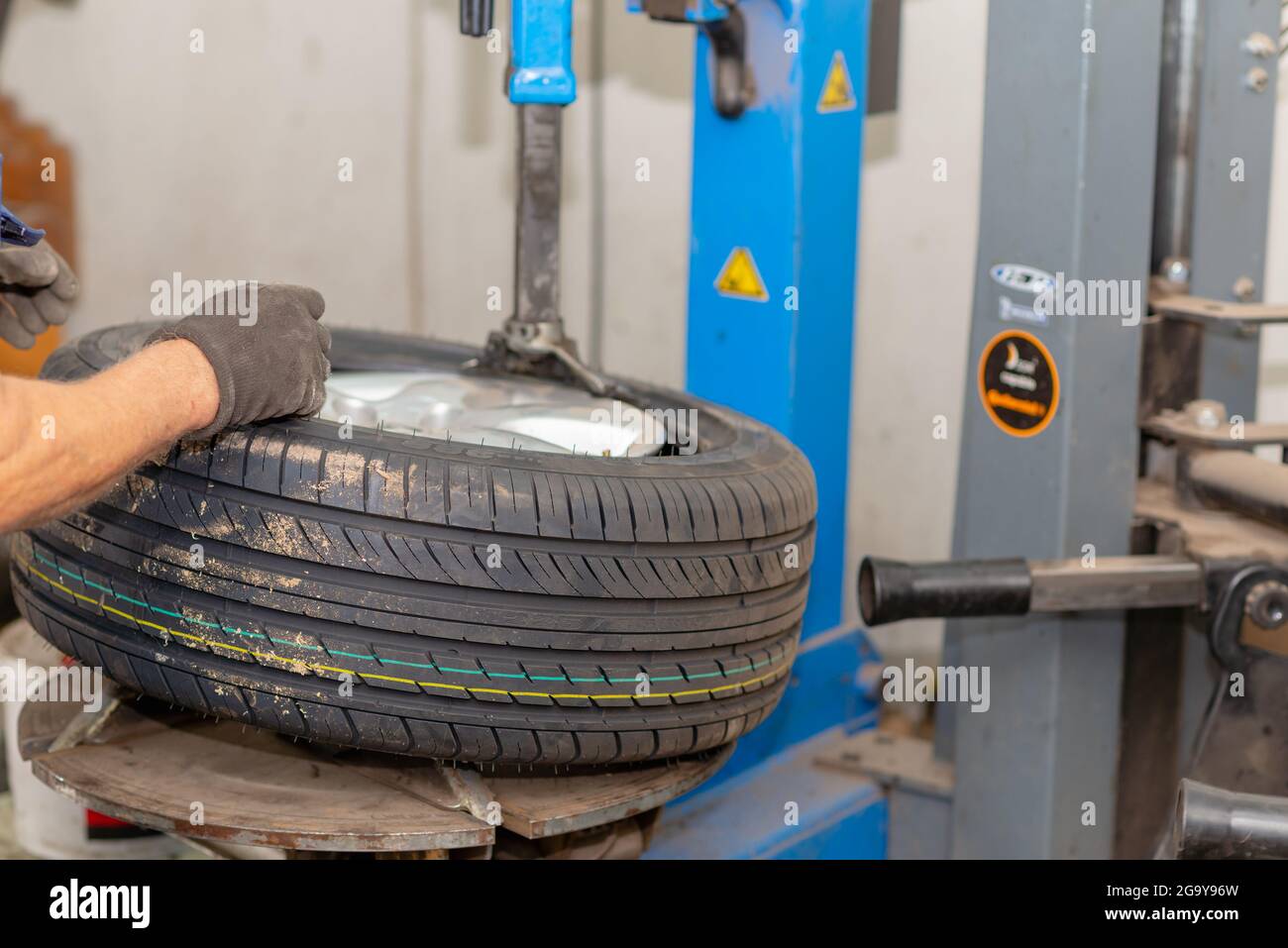 Mechanic changing tire in car service. Tire rotation machine.Car ...