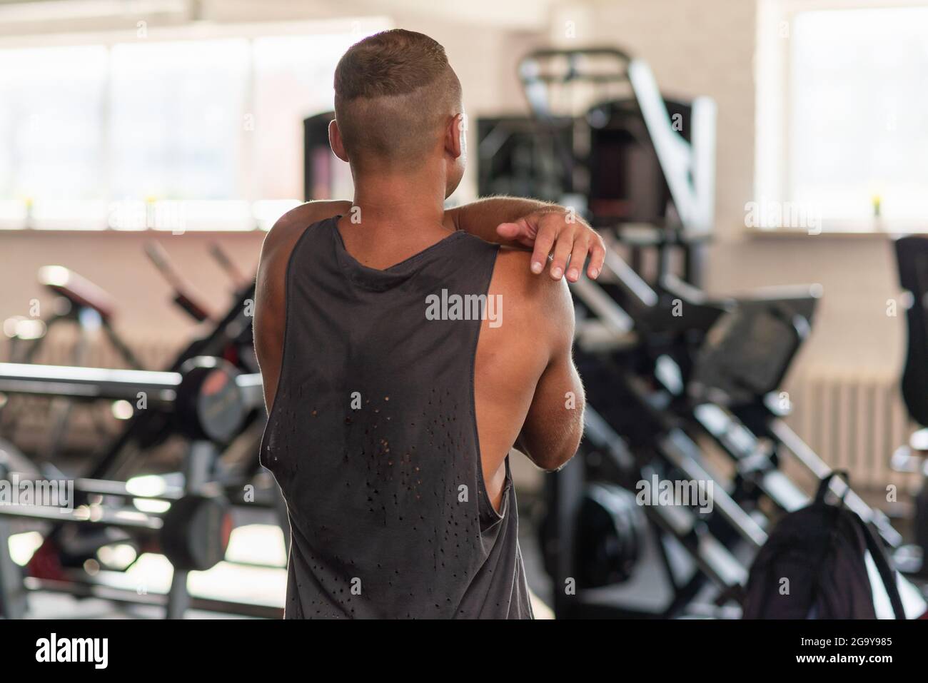 Fitness man warming up in gym. Male doing warm up stretching workout on ...