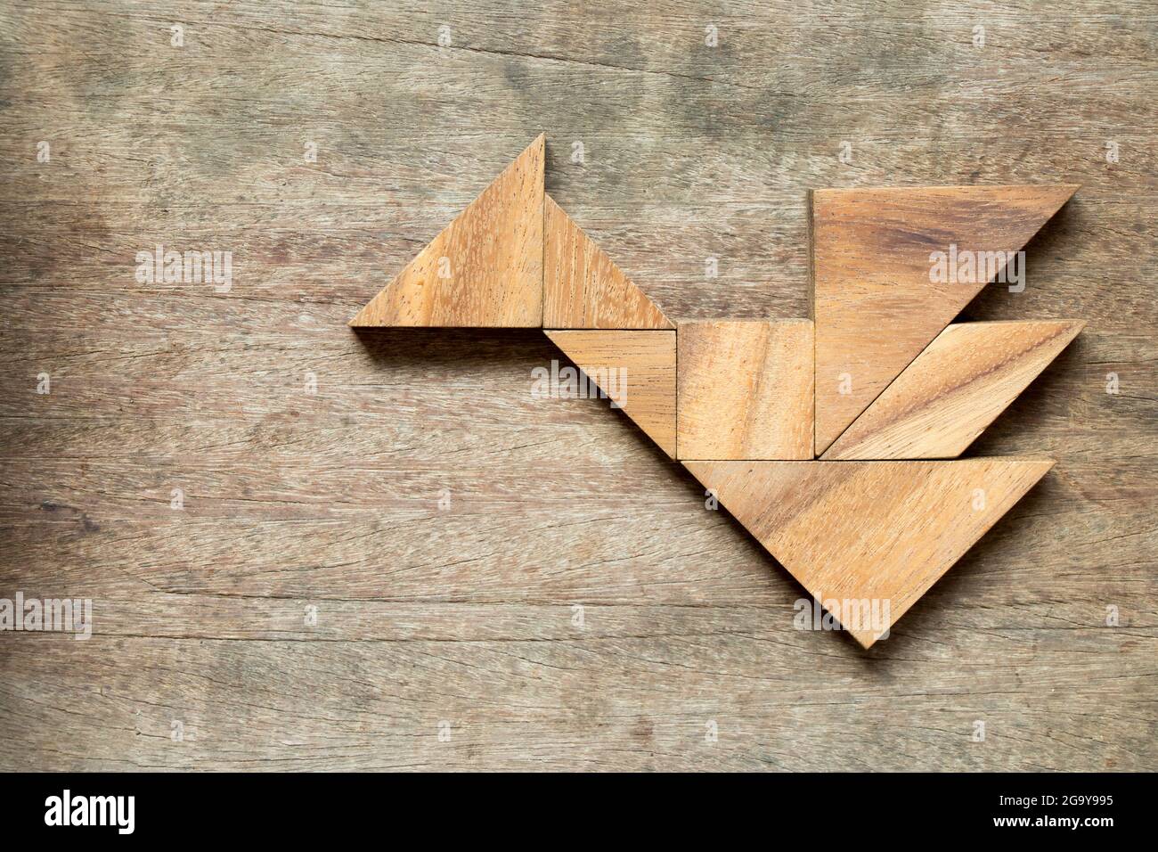 Tangram puzzle in bird or dragon shape on wood background Stock Photo ...