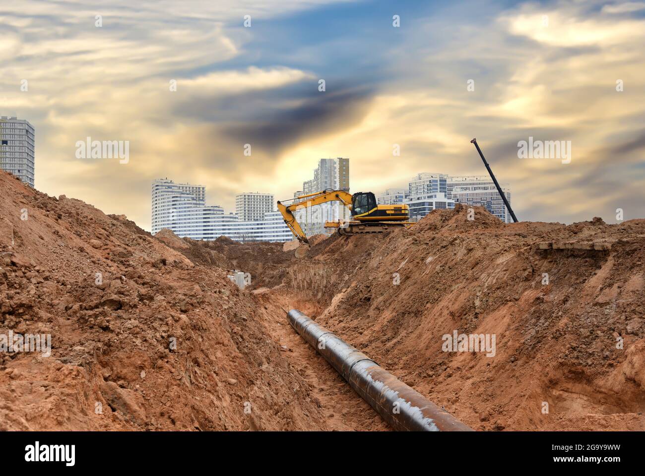 Excavator at construction site during laying sewer and main ...
