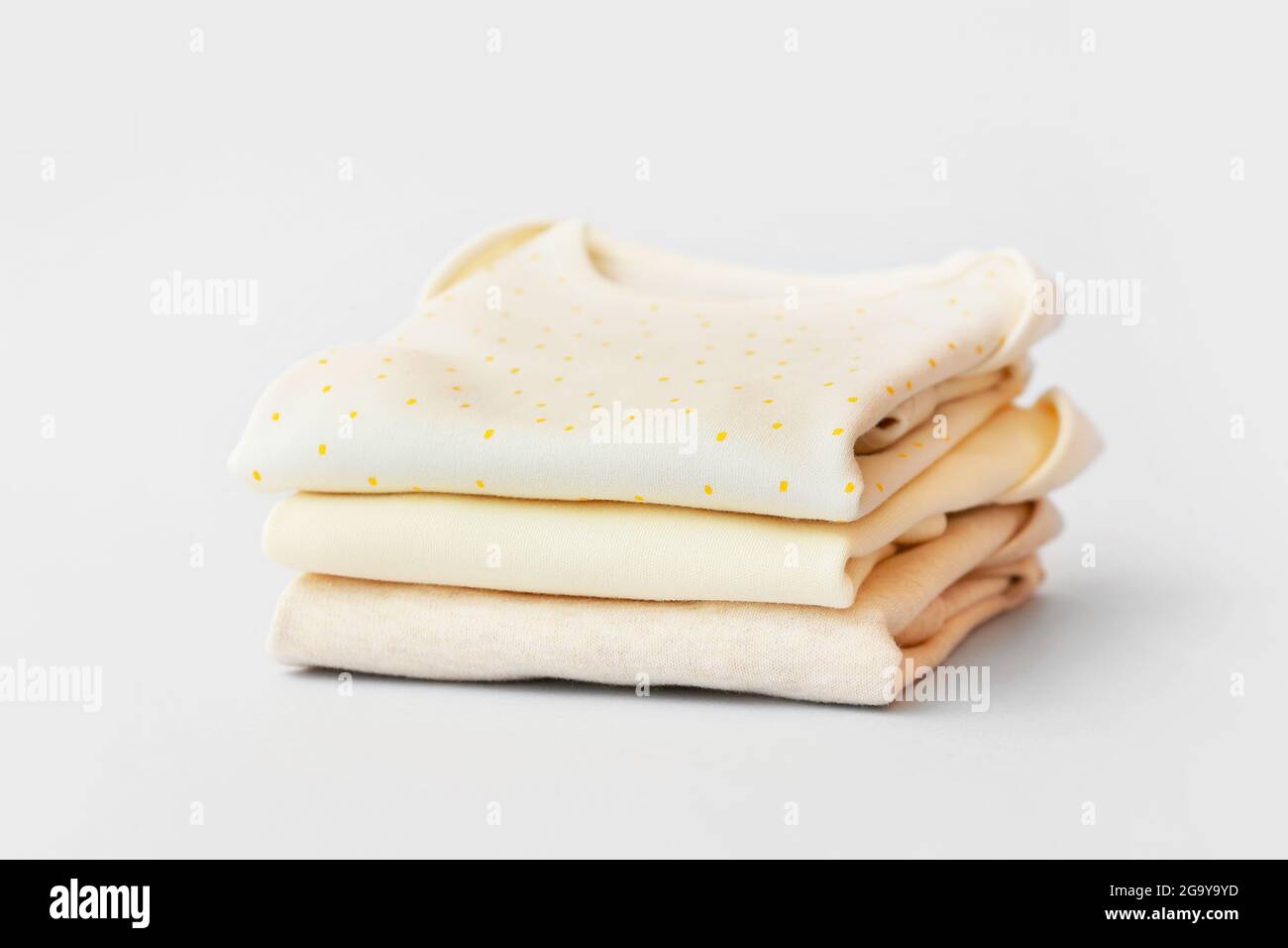 Stack of baby clothes on grey background Stock Photo - Alamy