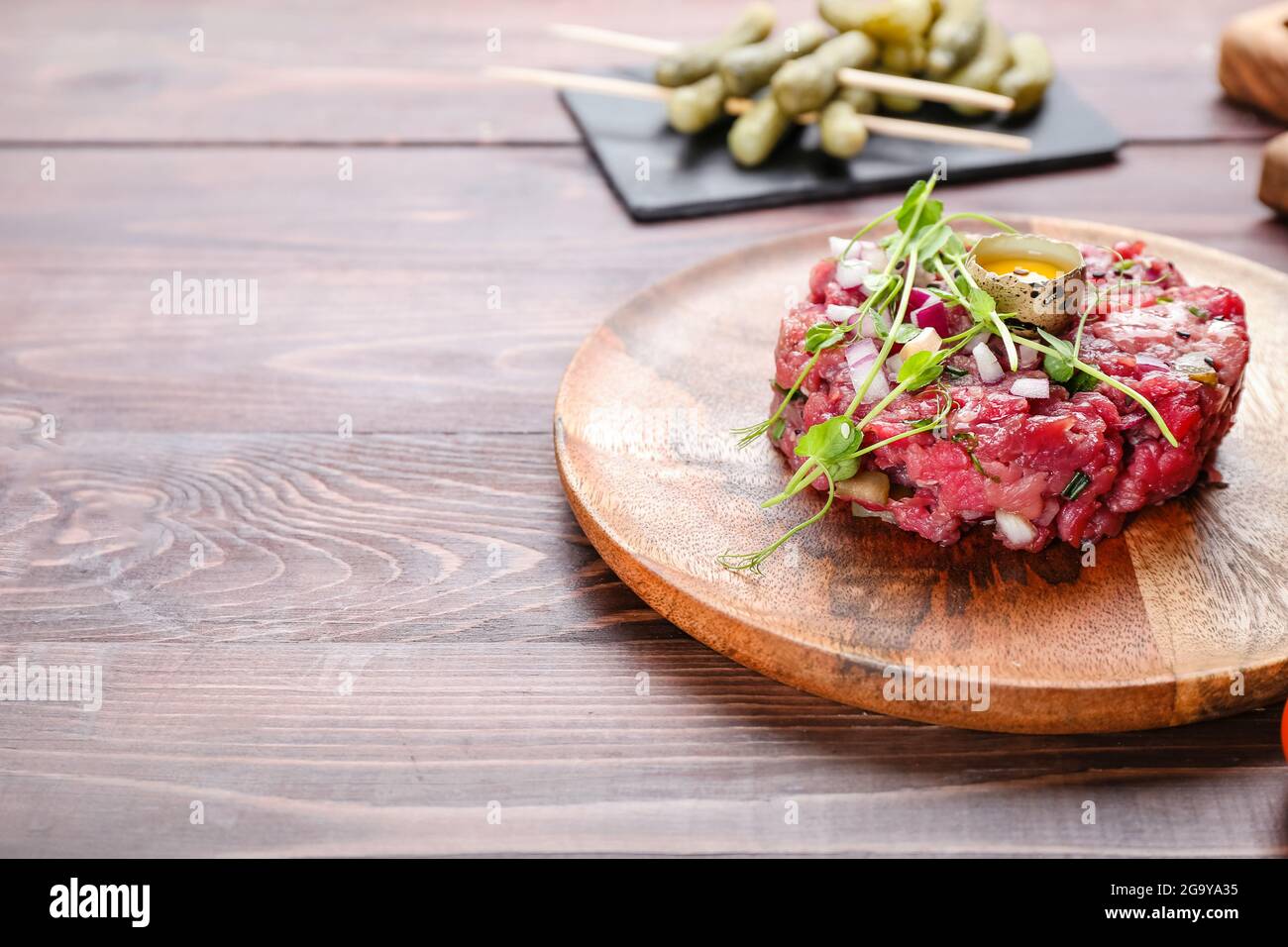 Plate with tasty beef tartare on wooden background, closeup Stock Photo ...