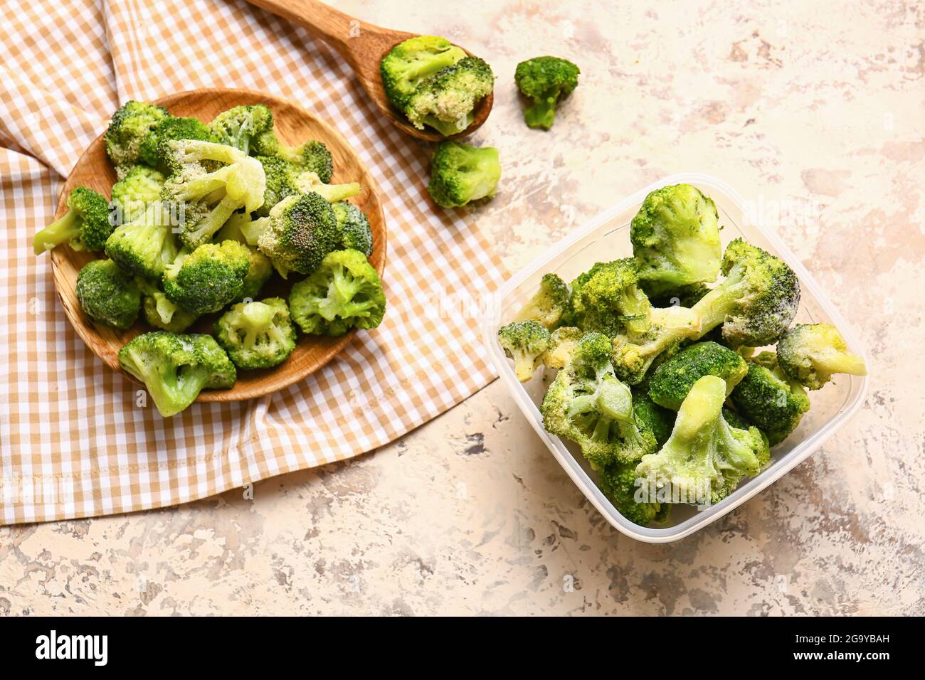 Container with frozen broccoli on light background Stock Photo - Alamy