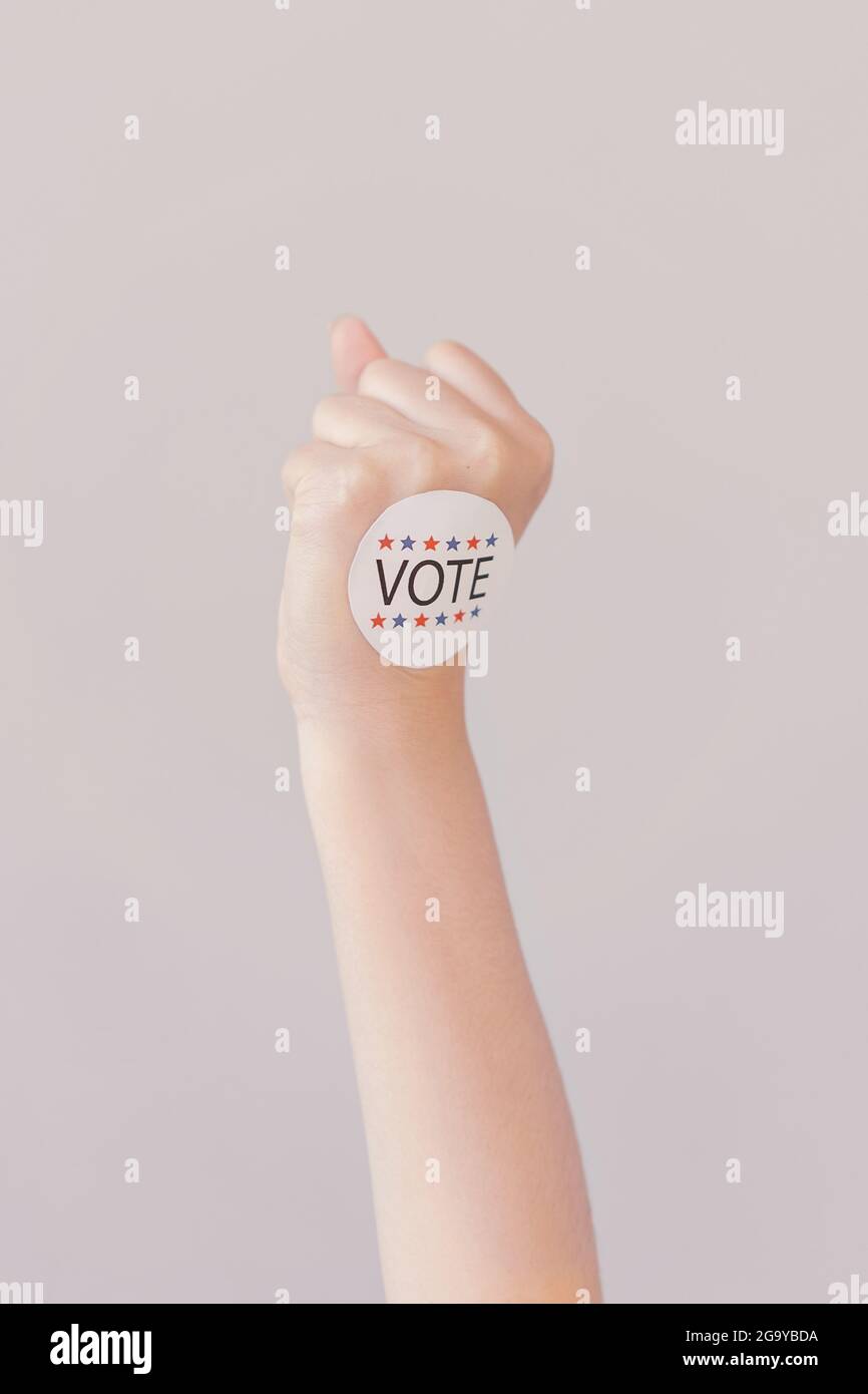 Person with vote sticker on first in white background Stock Photo - Alamy