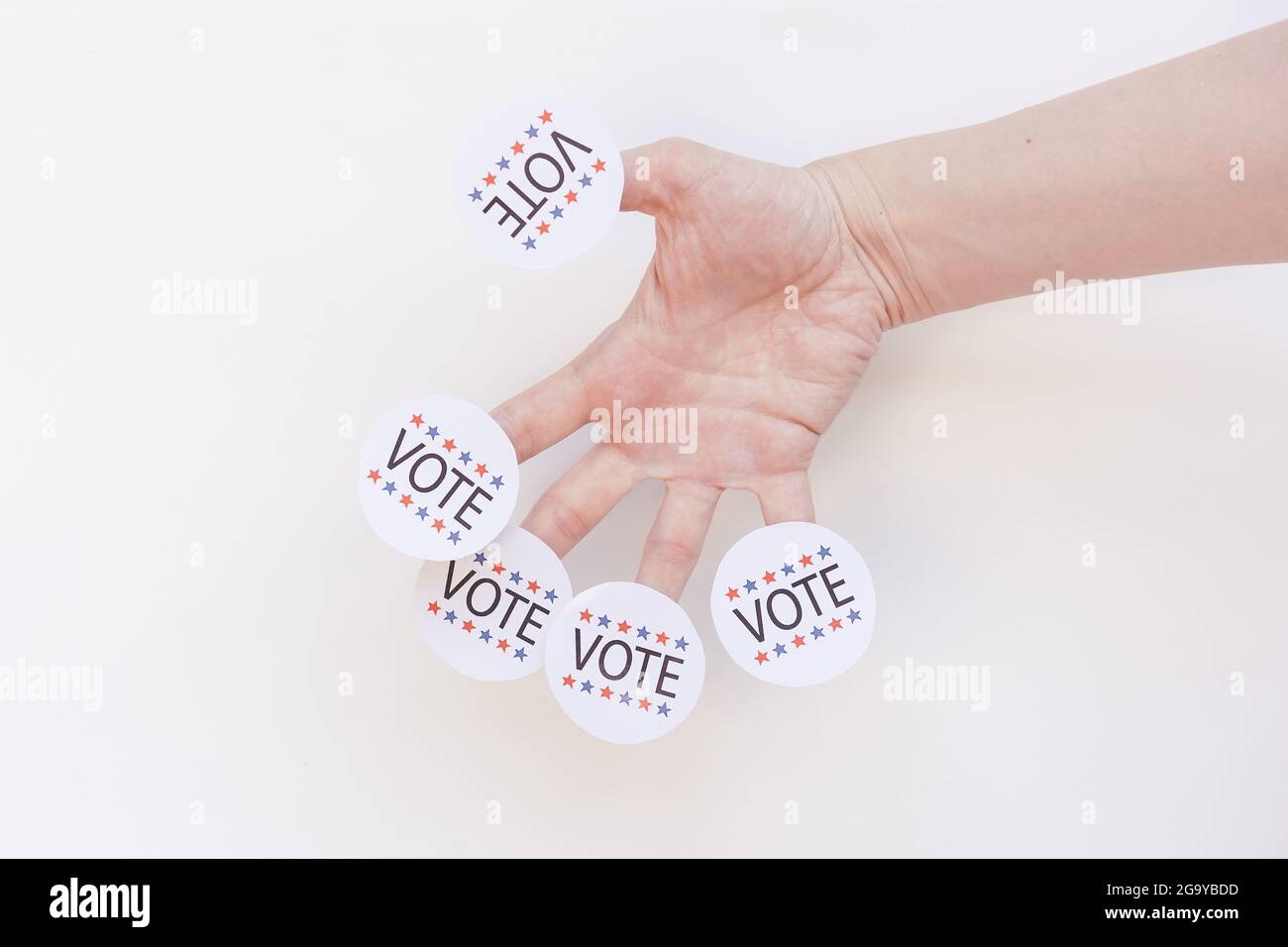 Vote badges on person s fingers in white background Stock Photo - Alamy