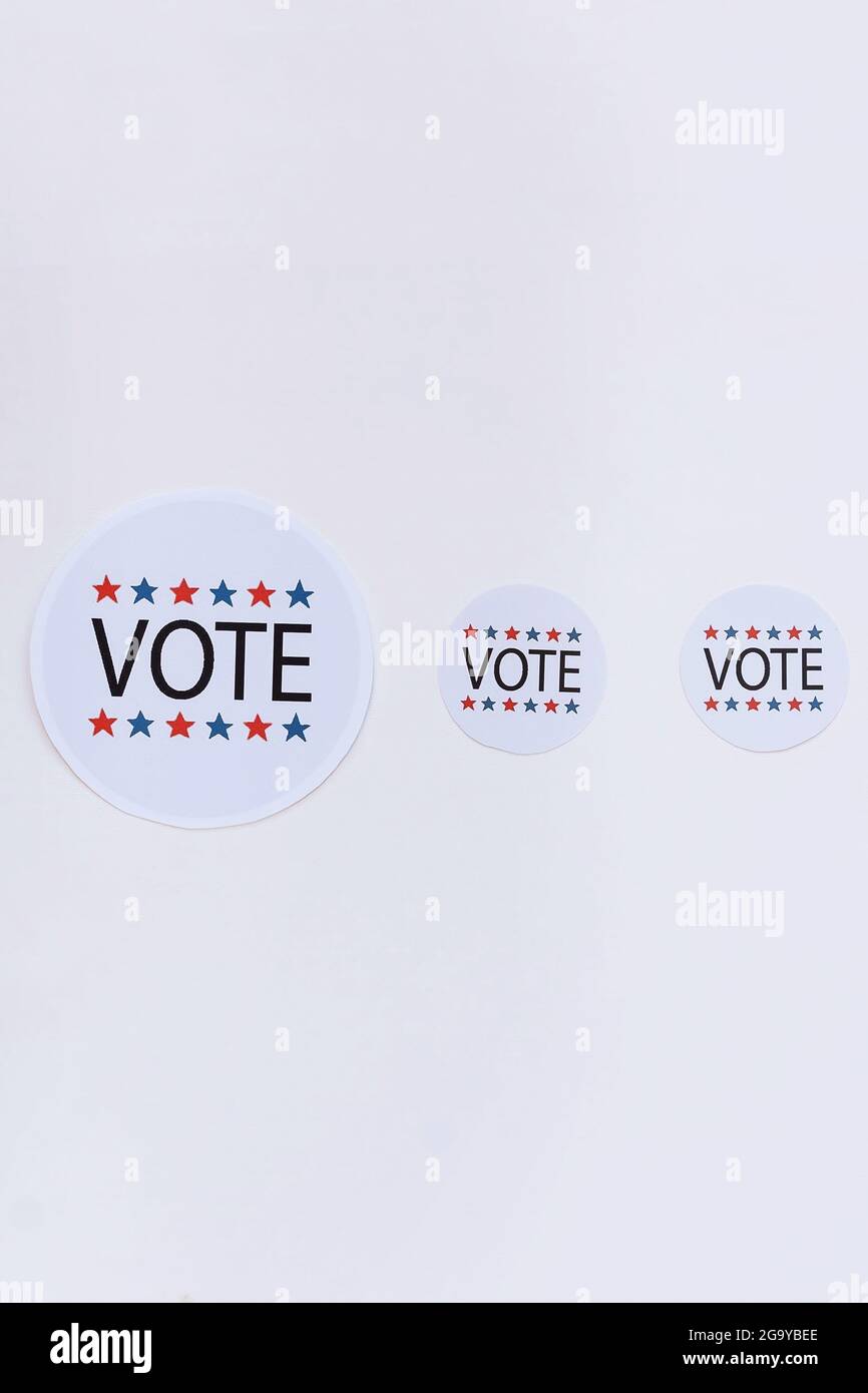 Vote badges on white surface in white background Stock Photo - Alamy