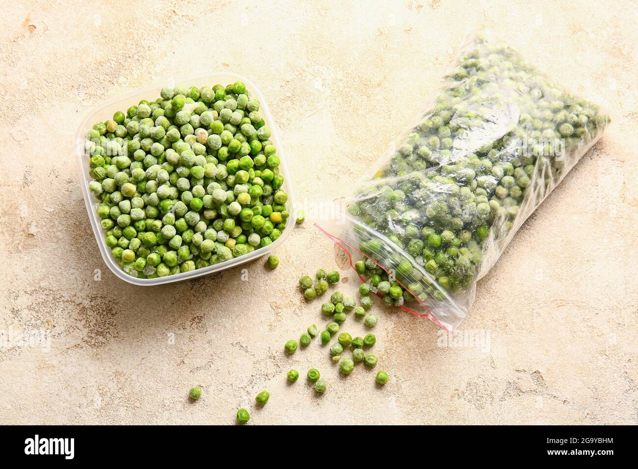 Container and bag with frozen green peas on light background Stock ...