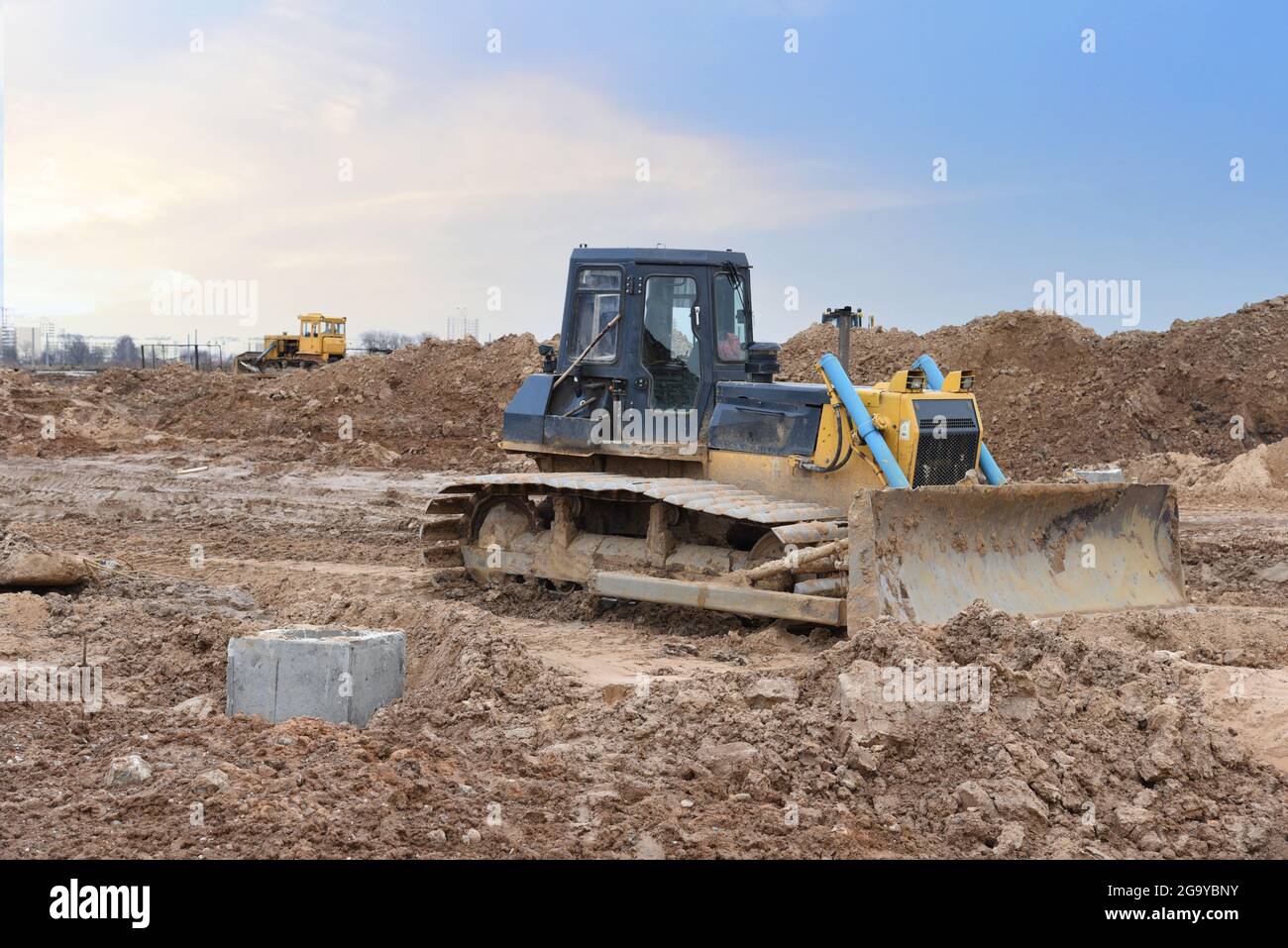 Dozer on earthmoving at construction site on sunset background ...