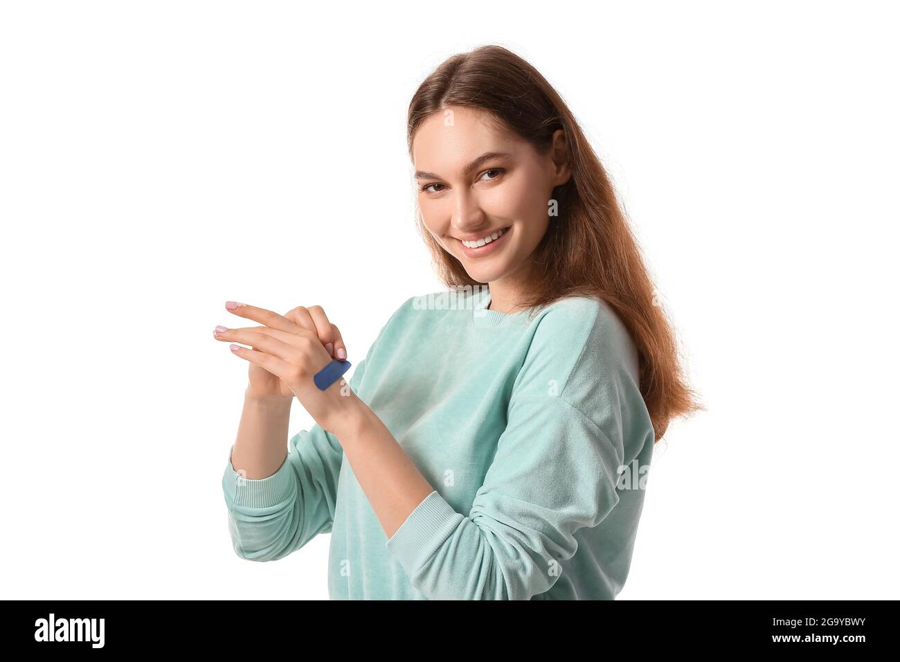 Young woman applying medical patch against white background Stock Photo ...