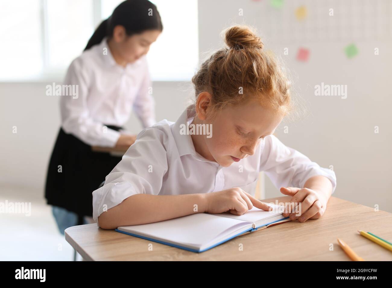 Cute little girl during lesson at school Stock Photo - Alamy