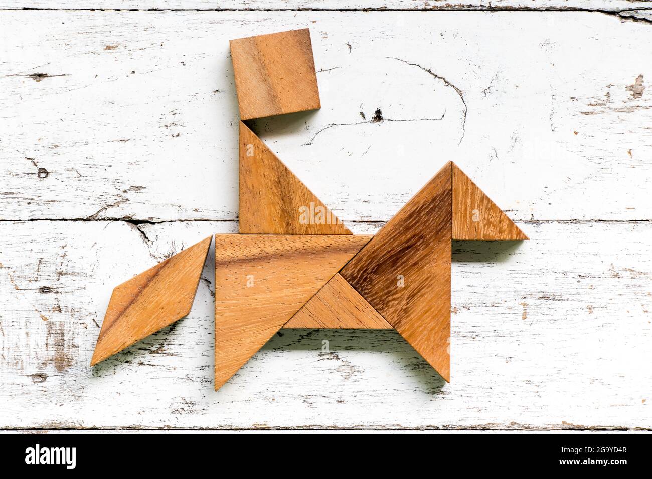 Tangram puzzle in man ride horse shape on old white wood background ...