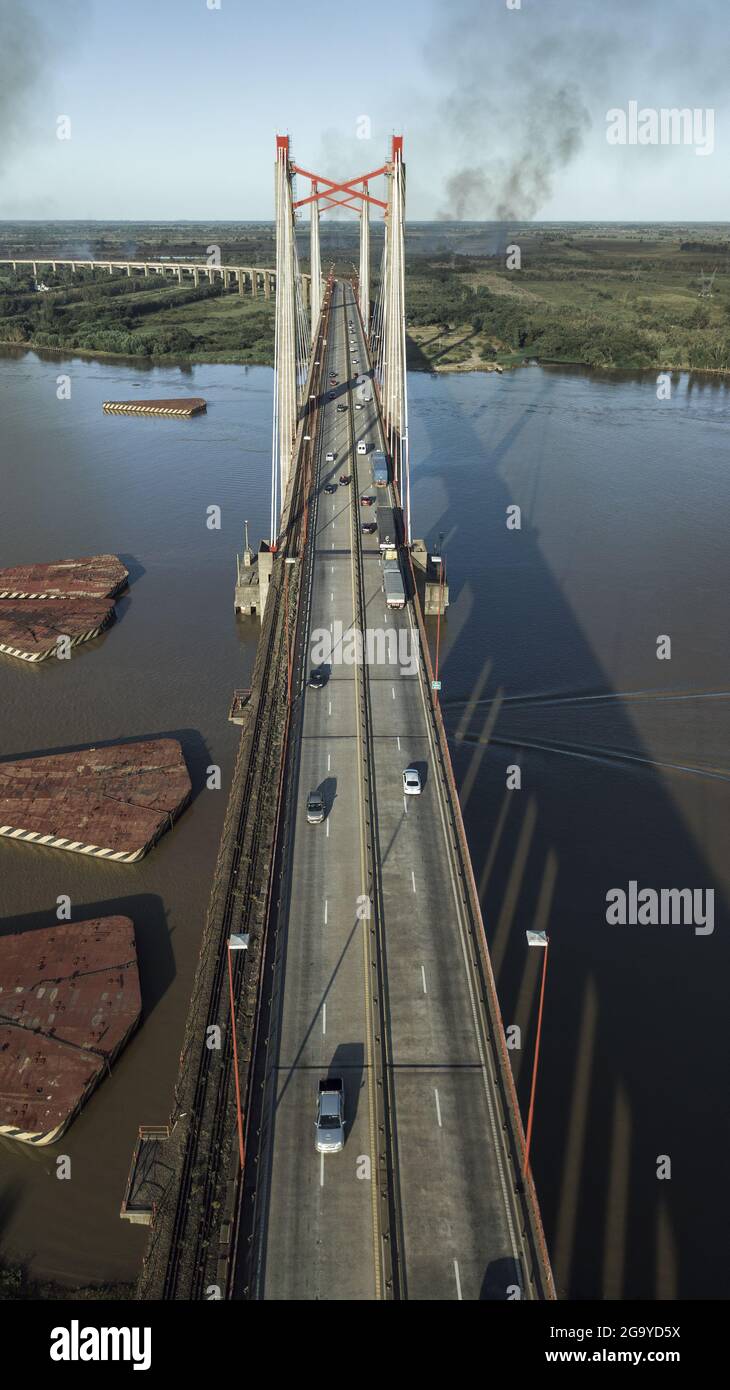 Cars passing by a hanging bridge over the river Stock Photo - Alamy