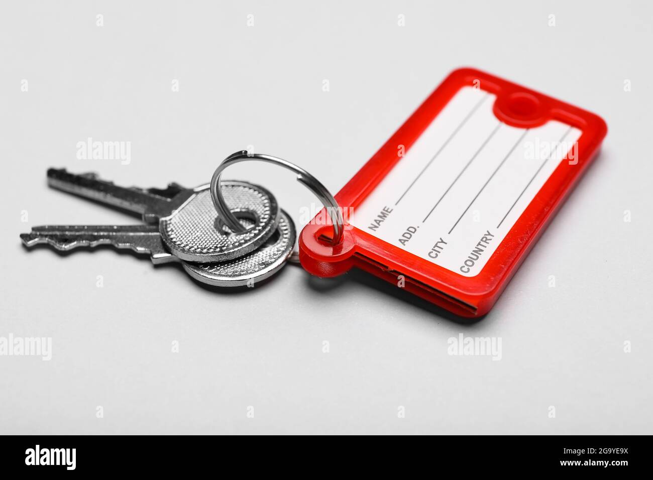 Keys with plastic tag on grey background Stock Photo - Alamy