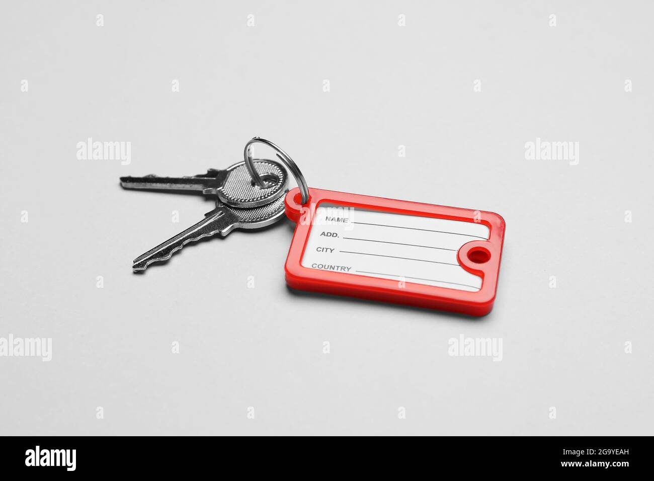 Keys with plastic tag on grey background Stock Photo - Alamy