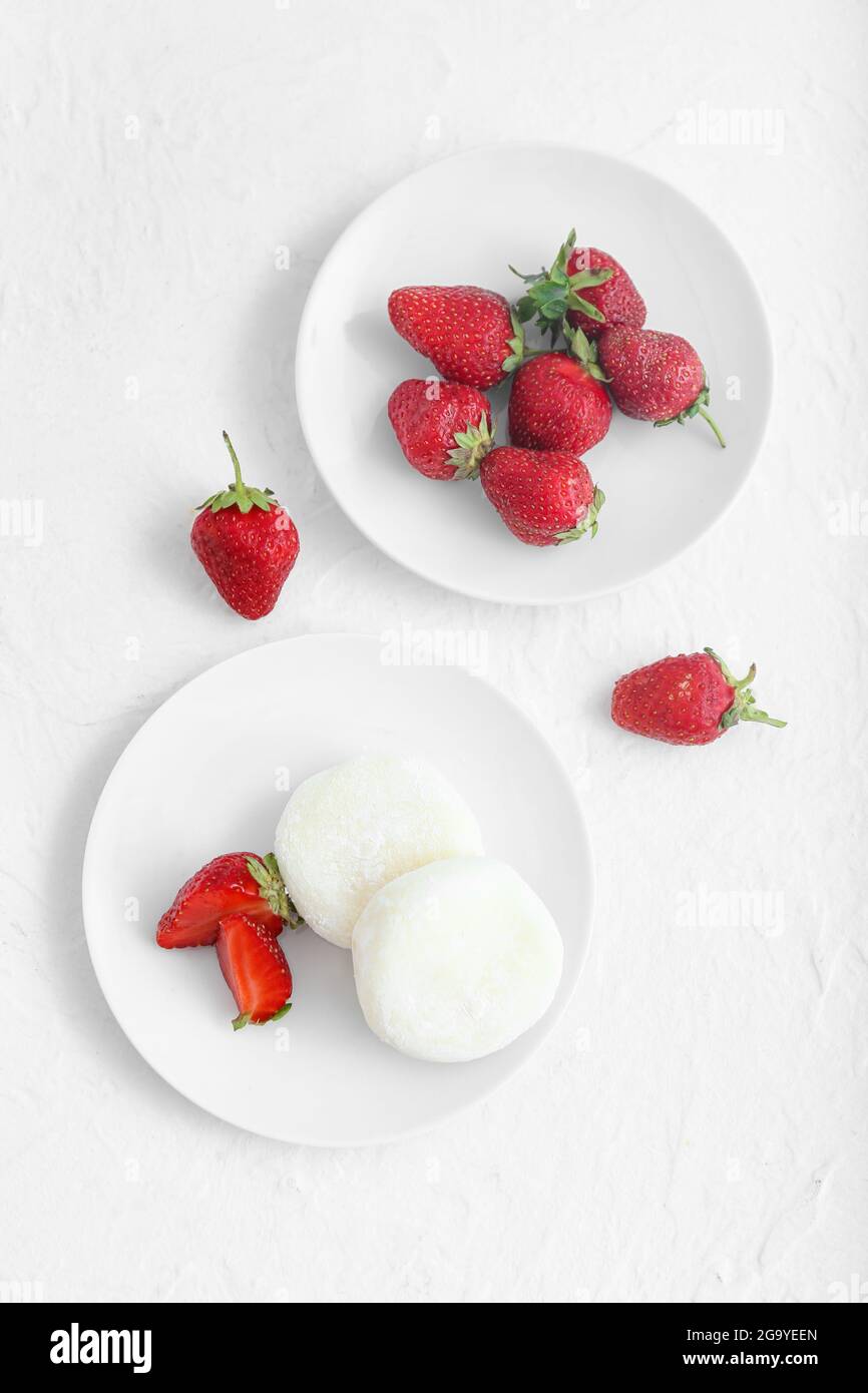 Plates with tasty Japanese mochi and strawberry on white background ...