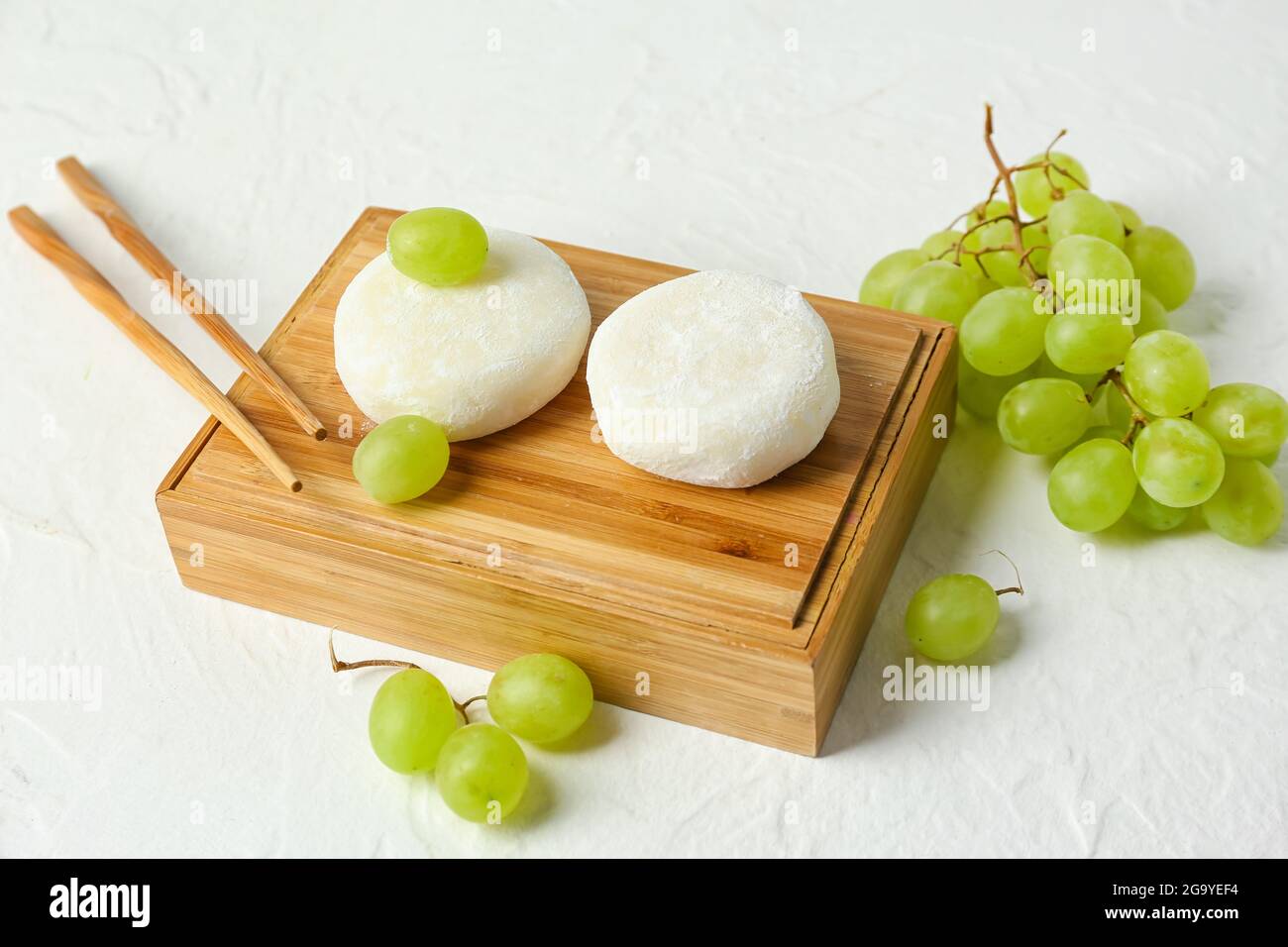 Board with tasty Japanese mochi and grapes on white background Stock ...