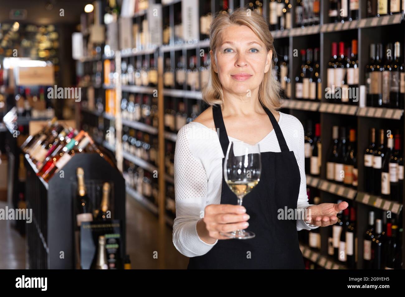 Woman owner of winery inviting to tasting wine Stock Photo - Alamy