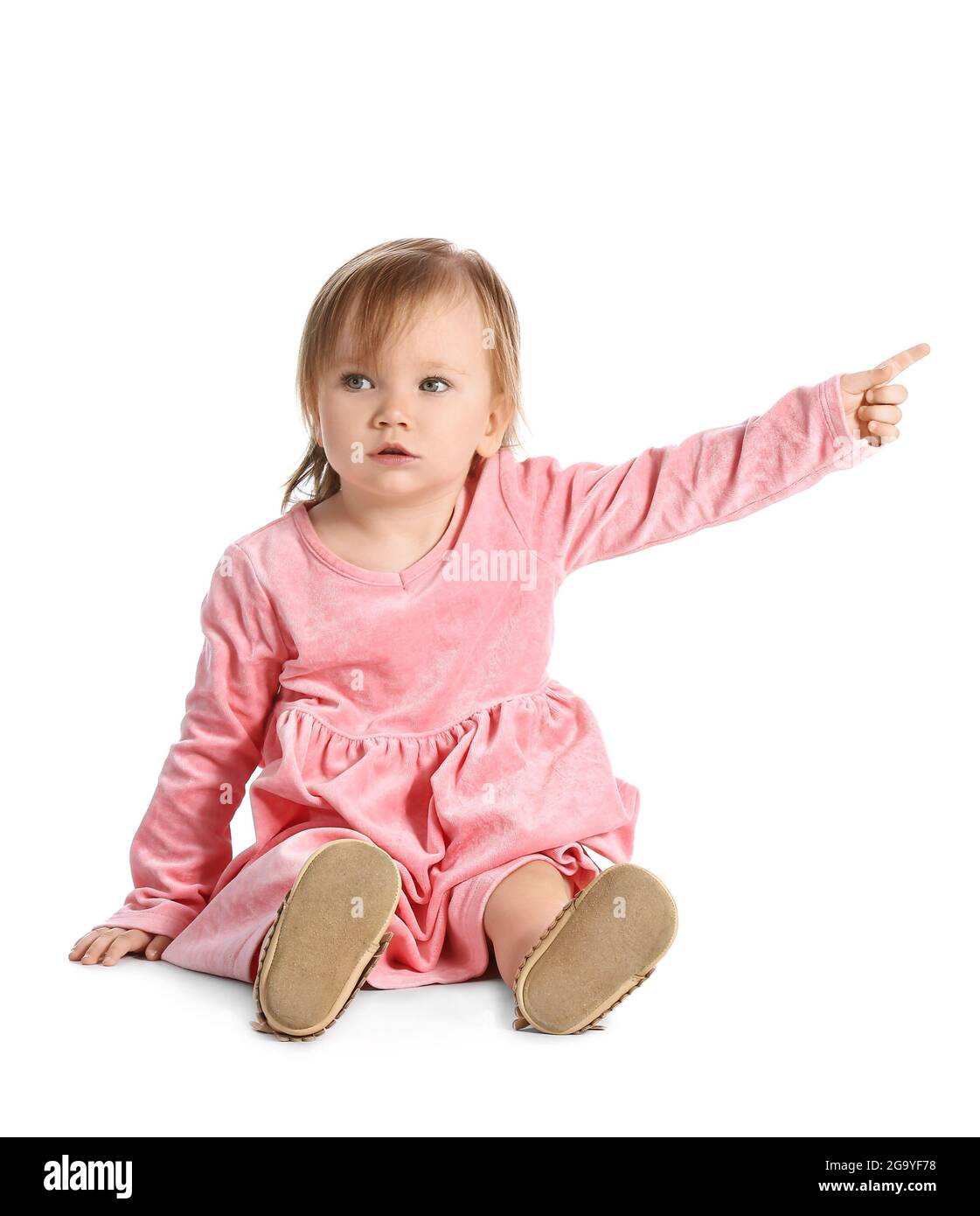 Cute baby girl pointing at something on white background Stock Photo ...