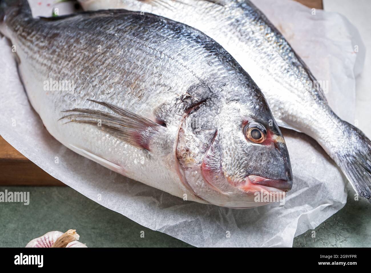 Board with raw dorado fishes on light background Stock Photo - Alamy