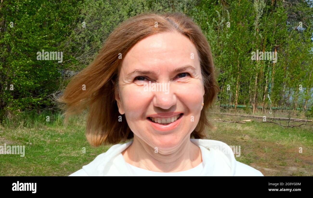 Beautiful mature woman face. Mid adult lady smiling outdoors. Portrait ...