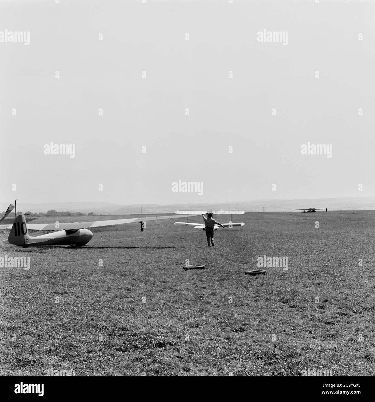 A glider prepares for take-off, towed by de Havilland Tiger Moth G-AJHU ...