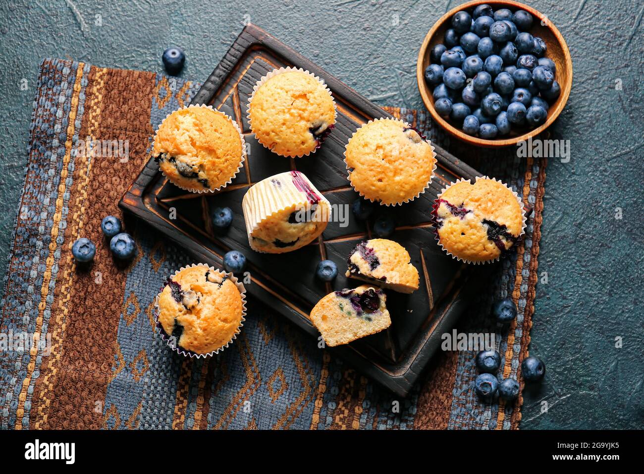 Composition with tasty blueberry muffins and berries on color ...