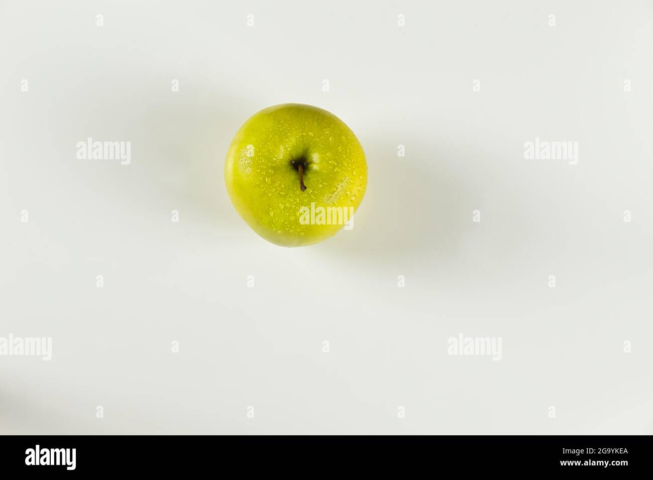 foreground of green apple with drops on white background viewed from ...