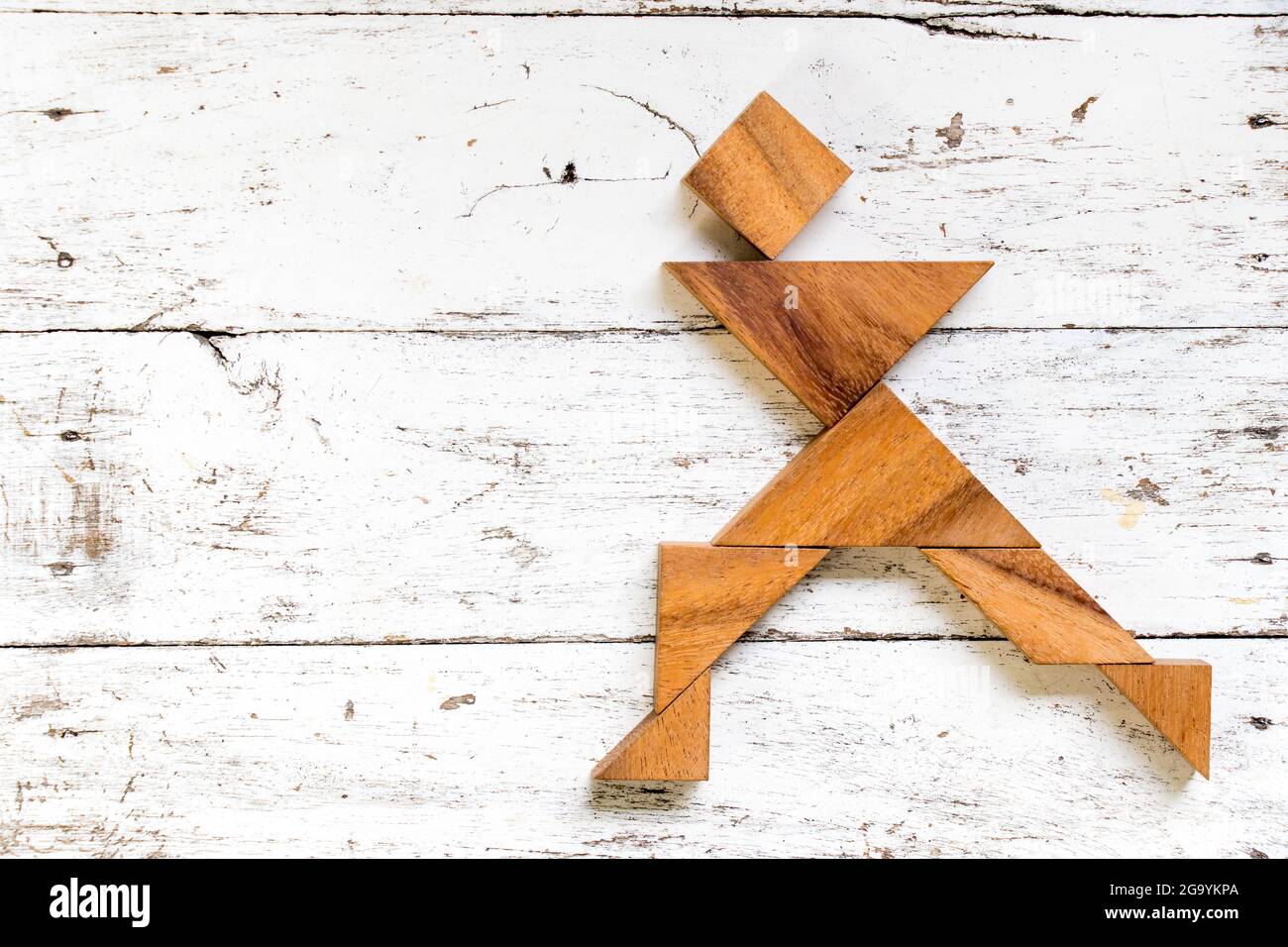 Tangram puzzle in happy running man shape on old white wood background ...
