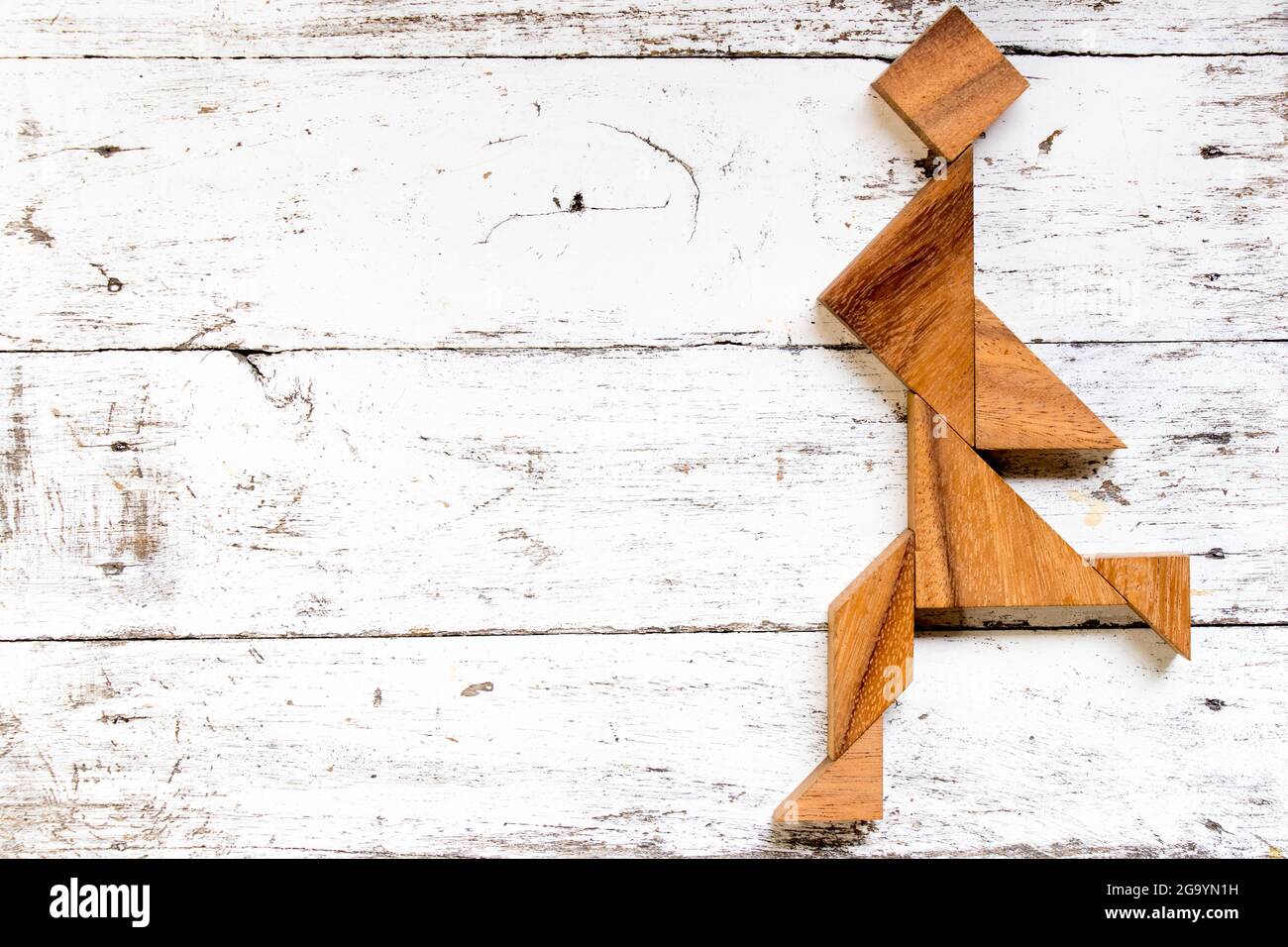 Tangram puzzle in happy running man shape on old white wood background ...