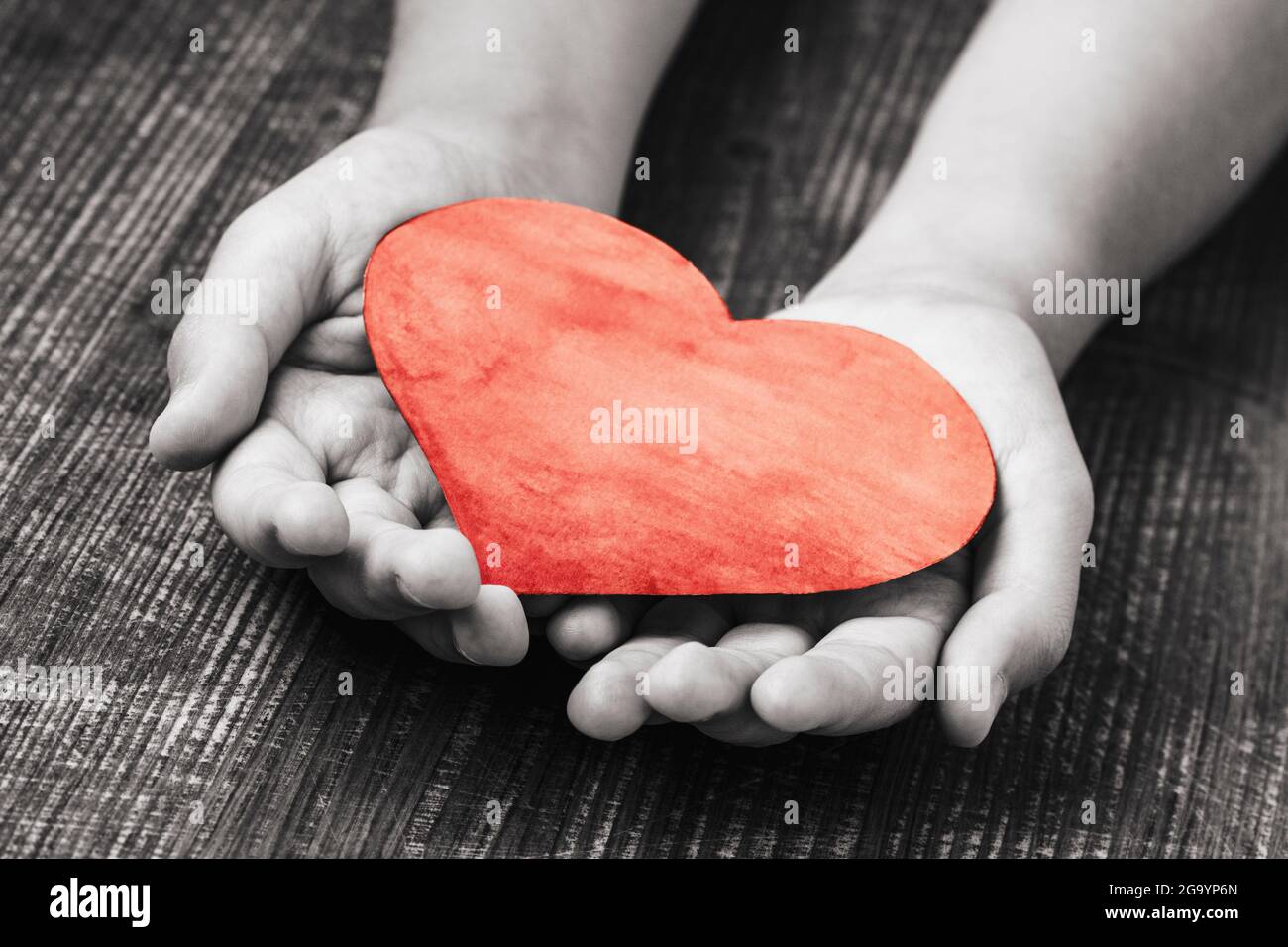 Child hands holding red heart . Monochrome photo with red heart Stock ...