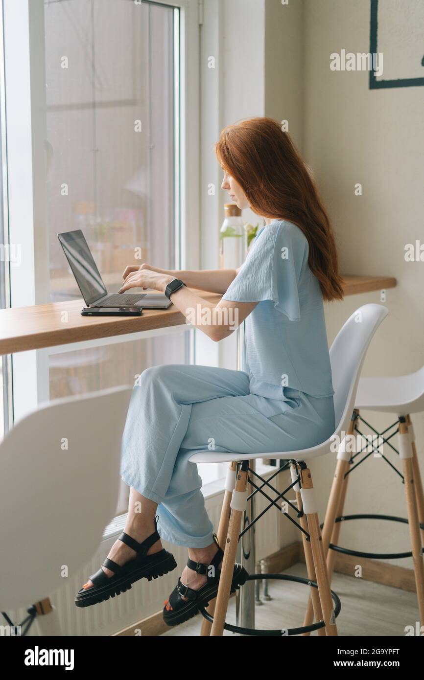 Vertical portrait of beautiful happy young woman typing on laptop ...