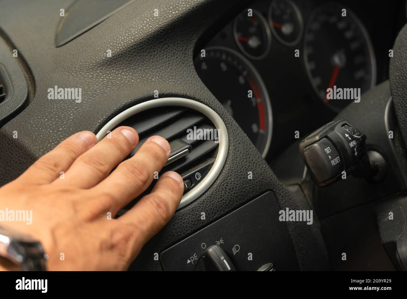 Male hand close-up adjusts the air conditioner in the car, car interior ...
