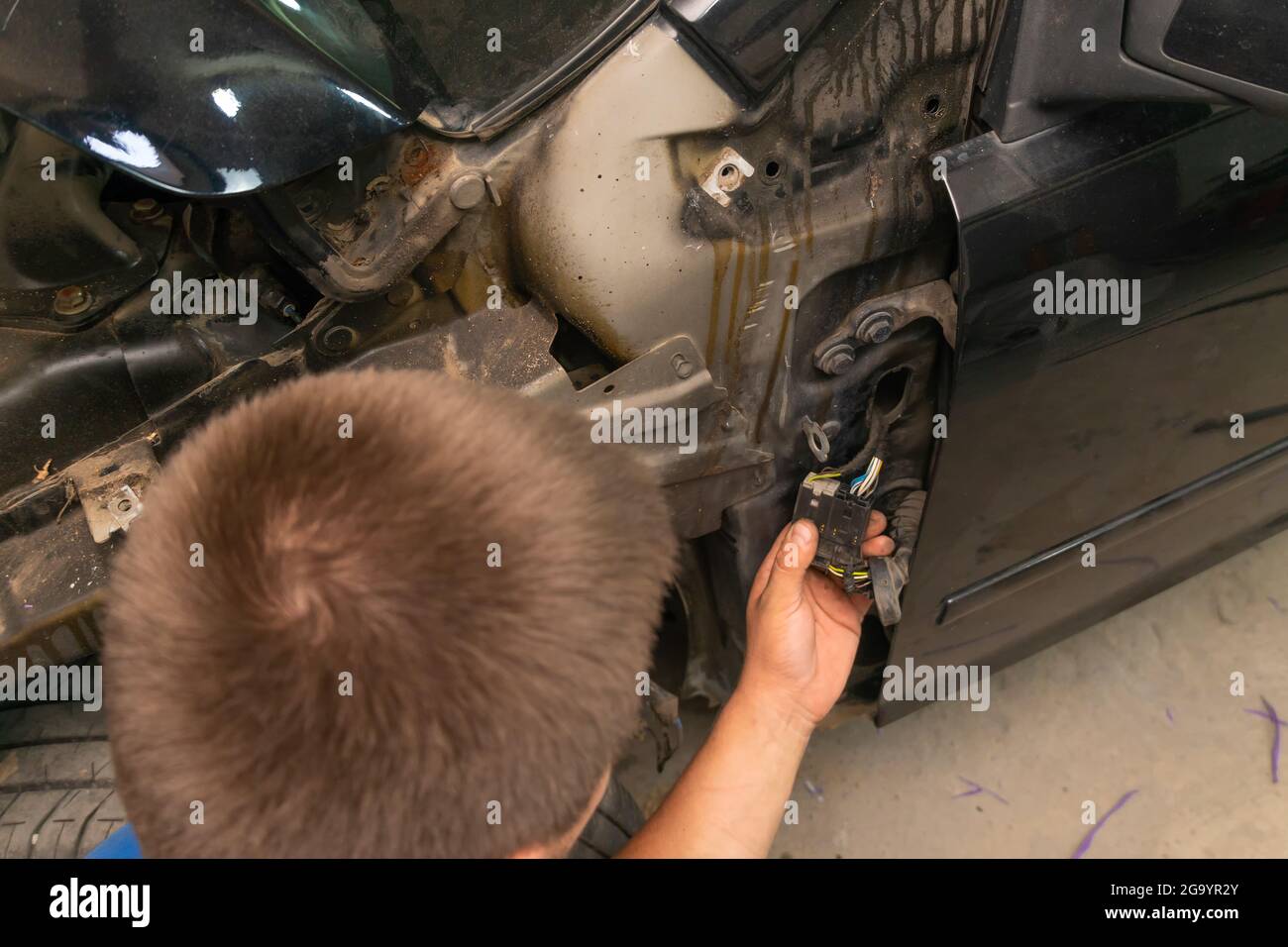 Specialist in repairing the electrical wiring of a car solves a problem ...