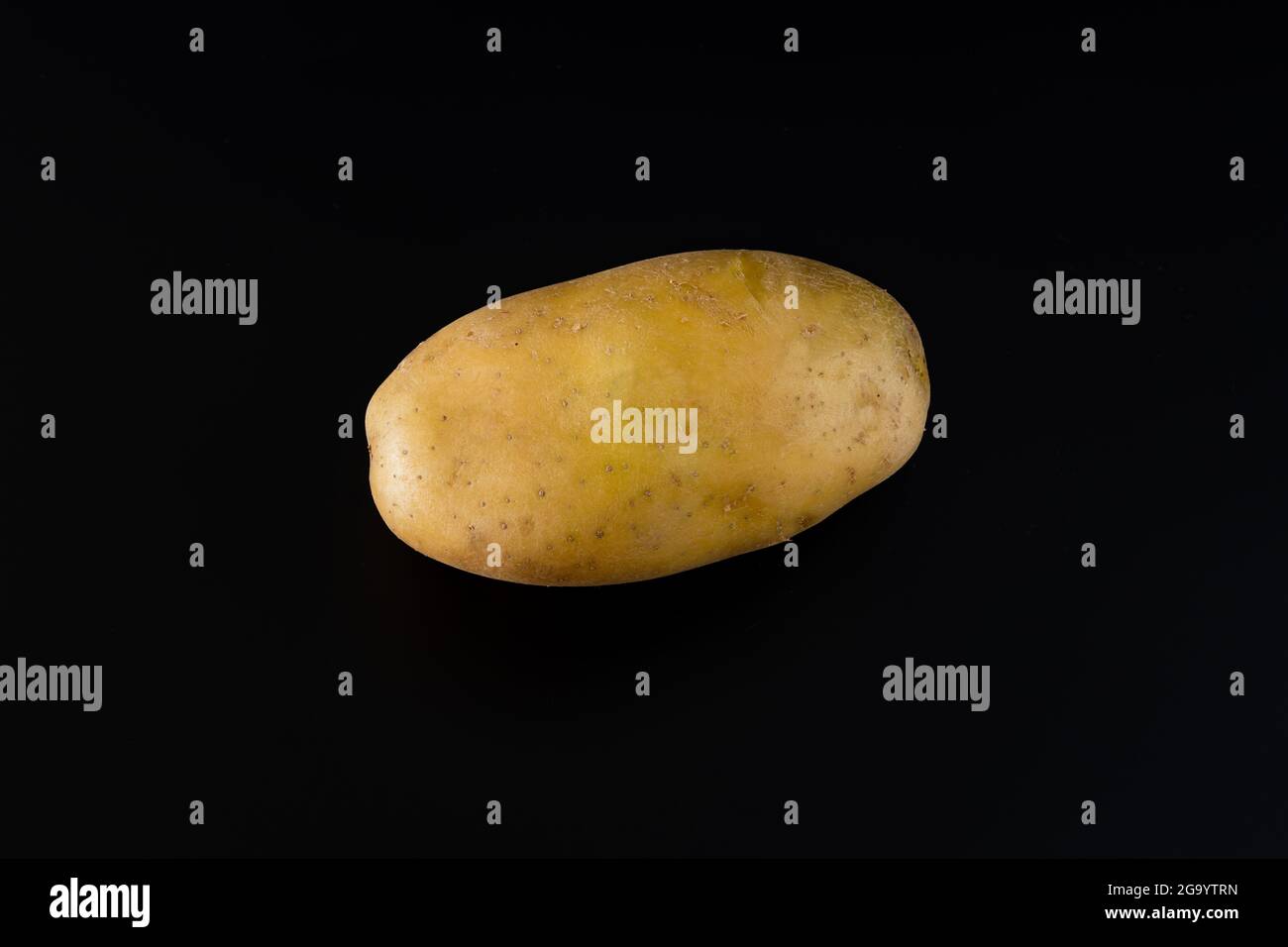 Top view of Freshly harvested single potatoes from a field on black ...