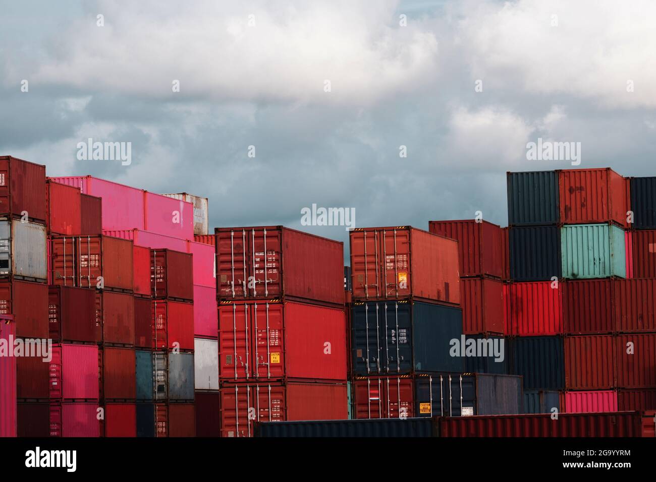 Containers piled up in a cargo yard against a blue sky. transport ...
