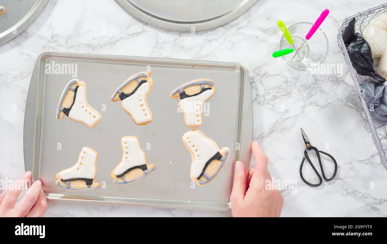 Flat lay. Icing figure skate shaped sugar cookies with royal icing ...