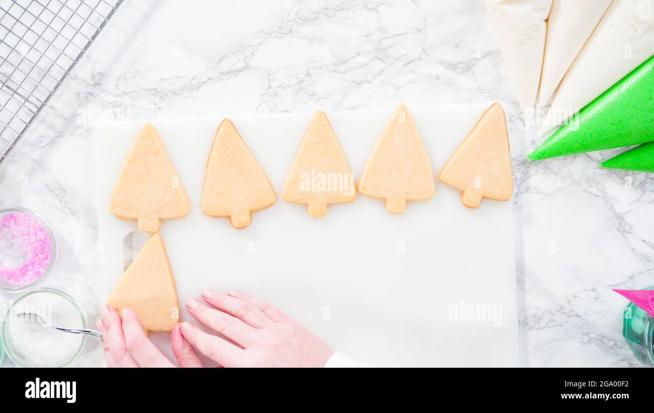 Flat lay. Stp by step. Icing Christmas tree-shaped sugar cookies with ...
