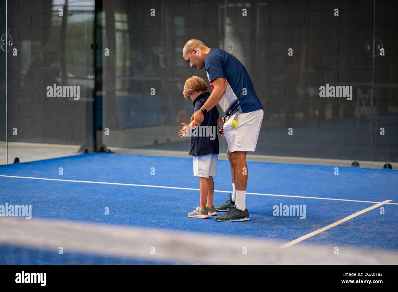 Monitor teaching padel class to child, his student - Trainer teaches ...