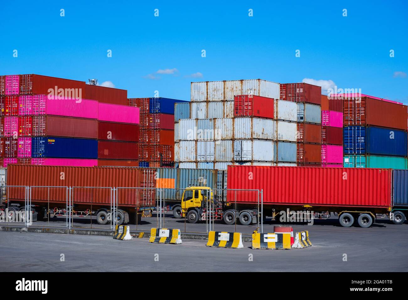 Containers piled up in a cargo yard against a blue sky. transport ...