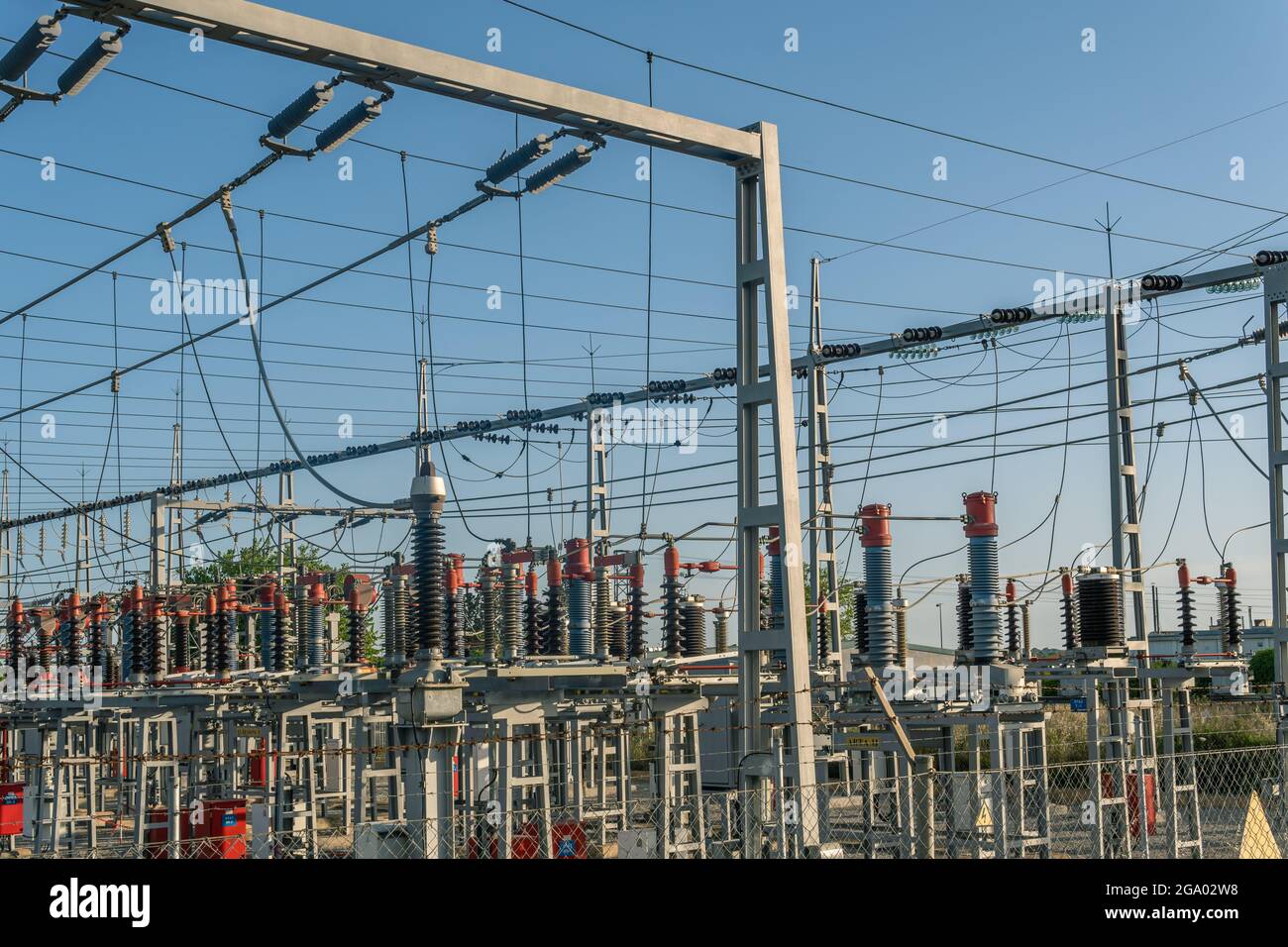 Metallic towers of a power station in the middle of a sunny field at ...