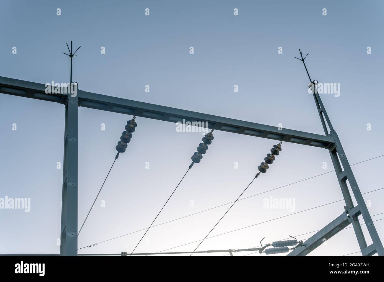 Metallic towers of a power station in the middle of a sunny field at ...