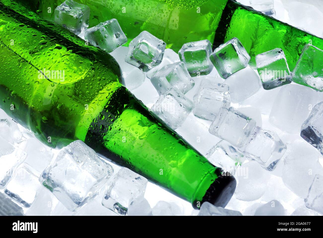Glass bottles of beer on ice cubes background Stock Photo - Alamy
