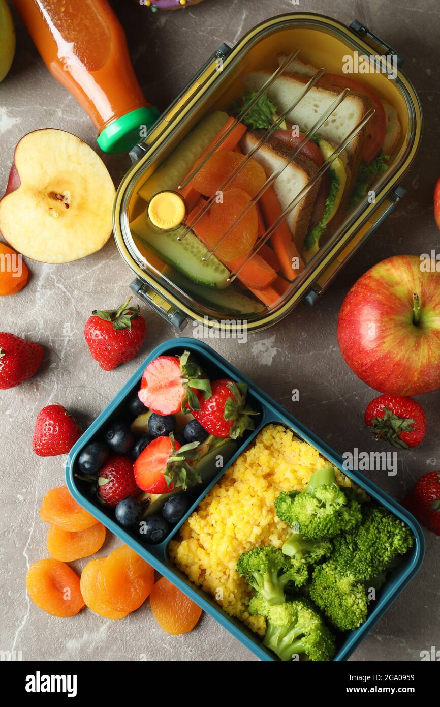 Lunch boxes with tasty food on gray textured table Stock Photo - Alamy