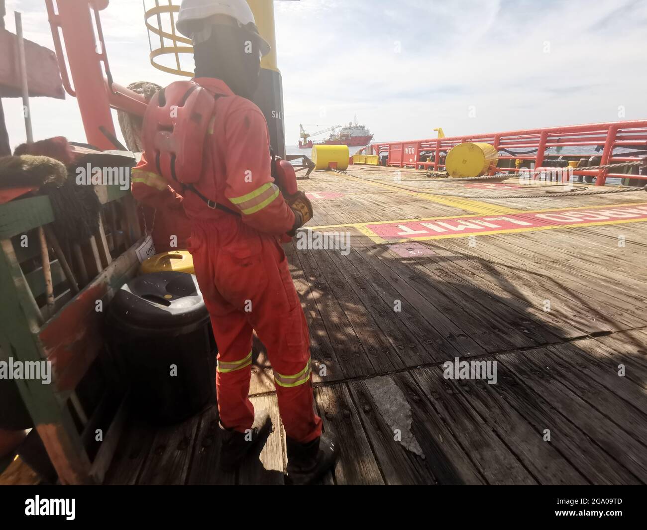 marine crew working on deck during anchor handling operation near oil ...
