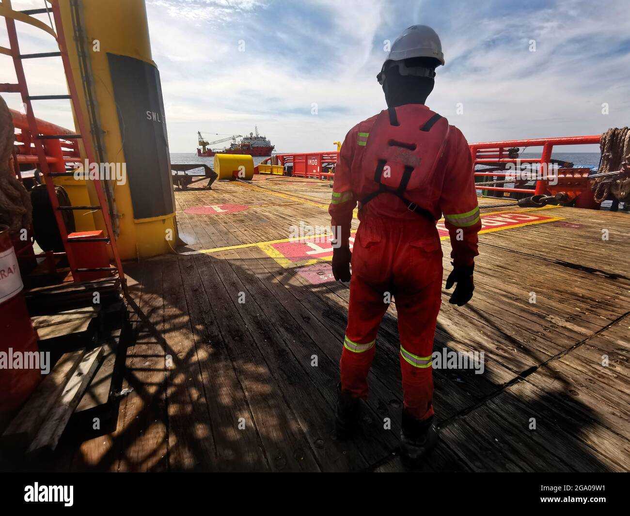 Marine crew working on deck during anchor handling operation near hi ...