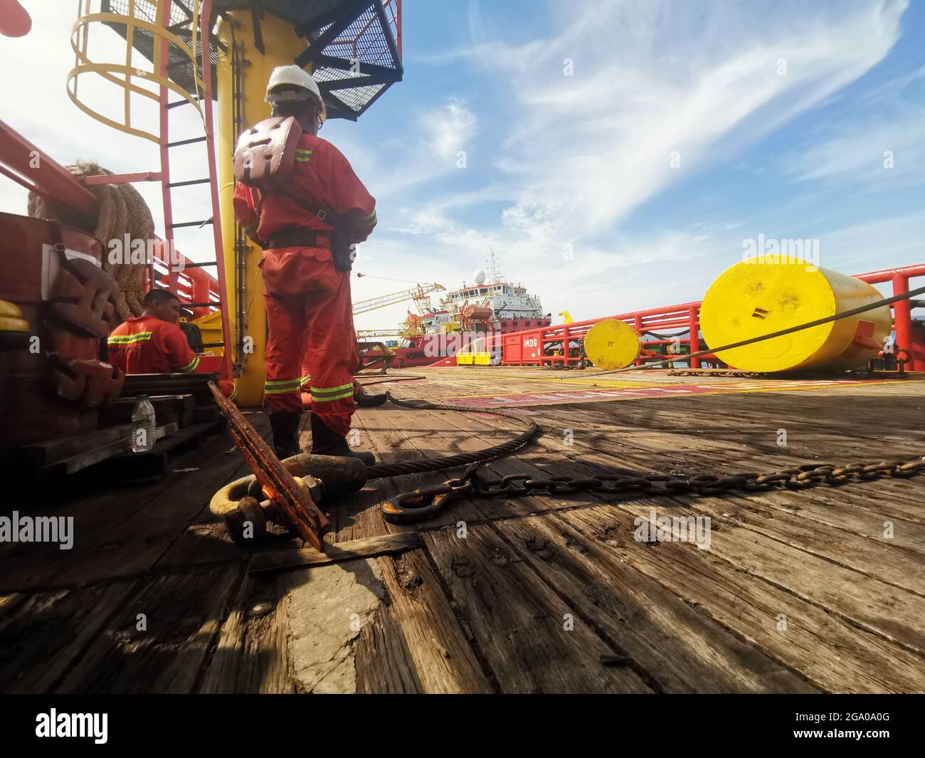 marine crew working on deck during anchor handling operation near oil ...
