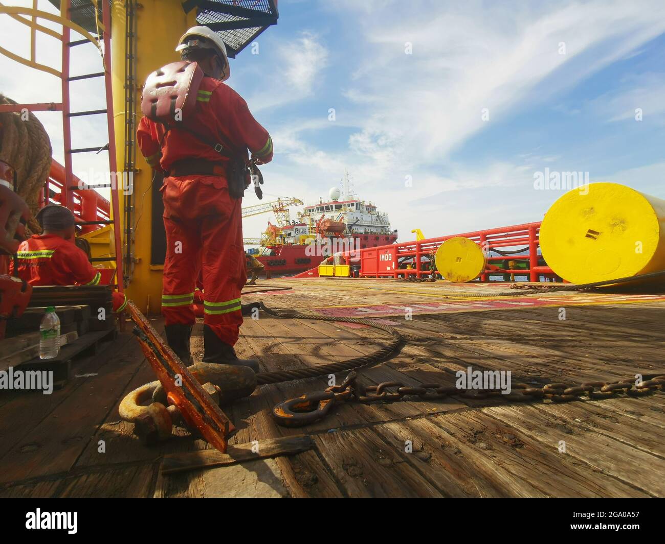 marine crew working on deck during anchor handling operation near oil ...