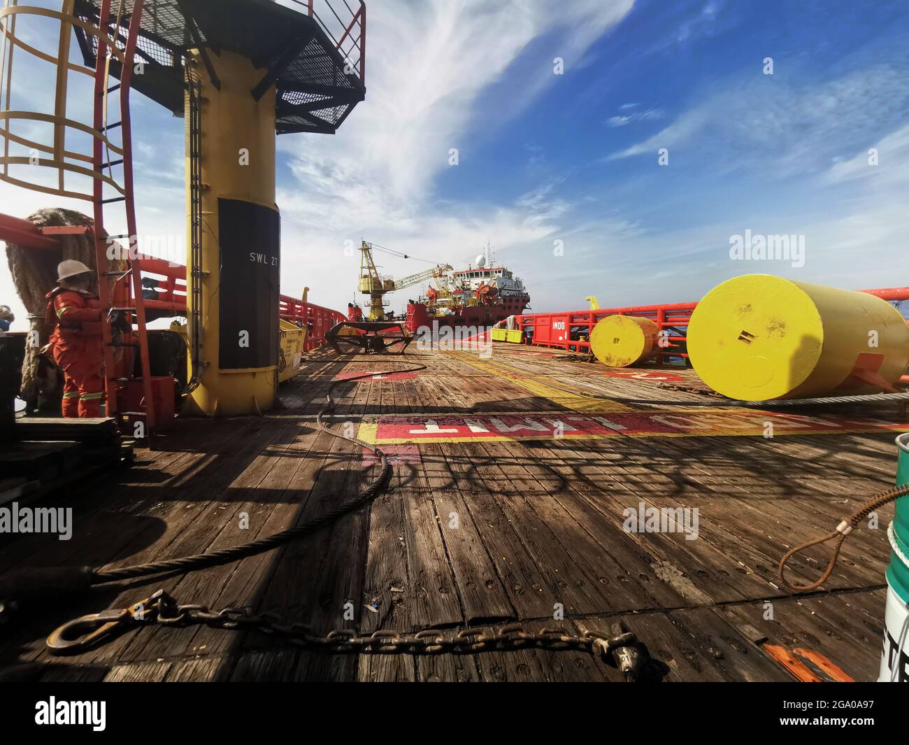 marine crew working on deck during anchor handling operation near oil ...