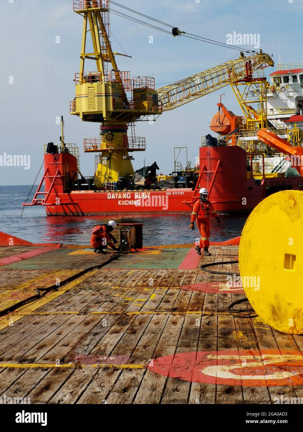 marine crew working on deck during anchor handling operation near oil ...